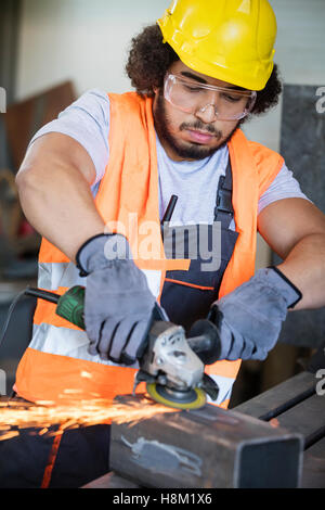 Worker grinding metal in a manufacturing plant Stock Photo - Alamy