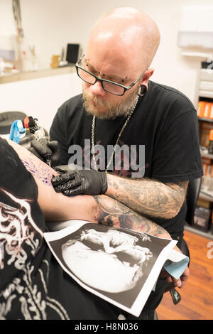 Tattoo artist working Stock Photo - Alamy