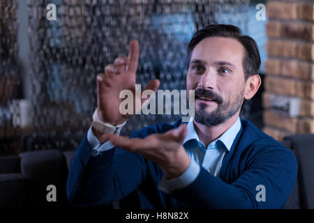 Virtual technology. Happy delighted nice girl smiling and looking at ...