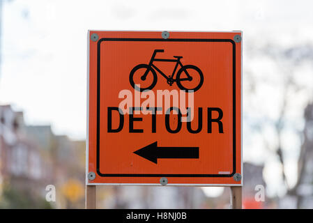 Orange road detour sign for bicycle in French. Arrow pointing straight ...