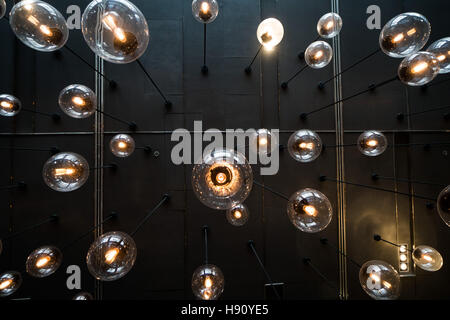 Bottom view of light bulbs background over dark wall Stock Photo - Alamy
