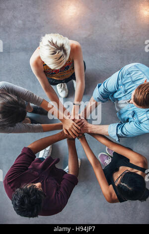 Unity and teamwork. College students putting hands together Stock Photo ...
