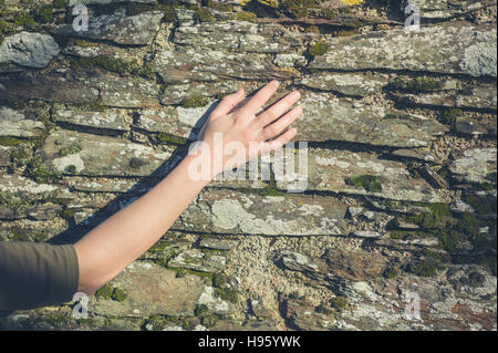 The hand of a young woman touching a rock surface Stock Photo - Alamy
