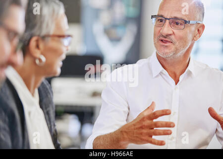Serious businessman explaining strategy to colleagues in spacious ...