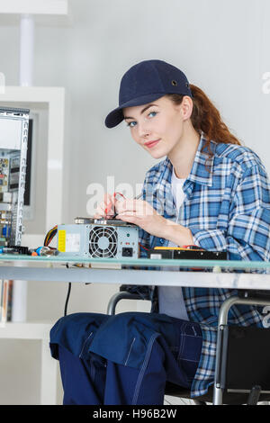 happy woman fixing computer at desk at work Stock Photo - Alamy