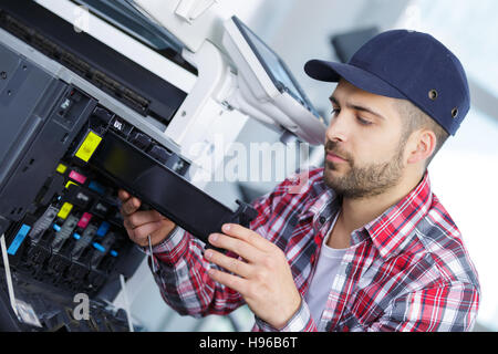 man repairing a printer at work Stock Photo - Alamy