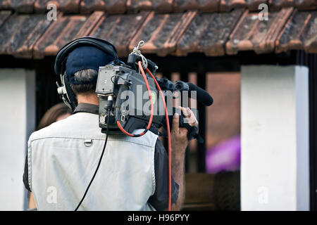 Back view cameraman filming news indoors Stock Photo - Alamy