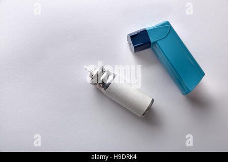 Cartridge and blue medicine inhaler on white glass table in a room ...