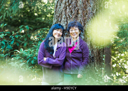 Woman and her senior mother posing near christmas tree Stock Photo - Alamy