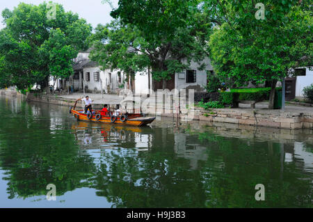 July 25, 2015. Tongli Town, China. A tourist boat moving by a coffee house on the water canals ...