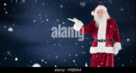 Composite image of santa shows something to camera Stock Photo - Alamy