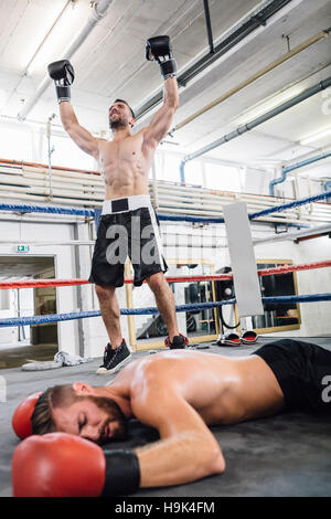 Boxer celebrating victory over his opponent Stock Photo - Alamy