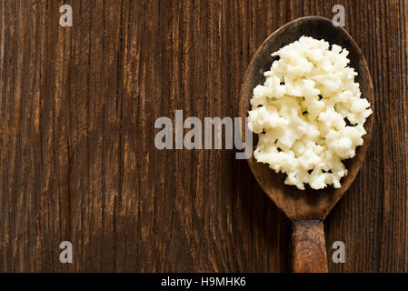 Kefir grains on a wooden spoon above a bowl of fresh milk Stock Photo ...