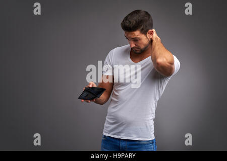 A poor handsome young man feeling stressed looking in to the camera and ...