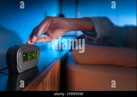 Woman pressing snooze button on early morning digital alarm clock Stock ...