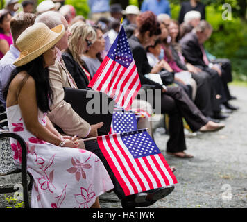 The image depicts a naturalization ceremony, where individuals are ...