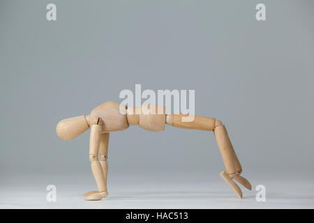 Wooden figurine exercising on floor Stock Photo - Alamy