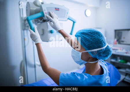Nurse adjusting x-ray machine over patient Stock Photo - Alamy