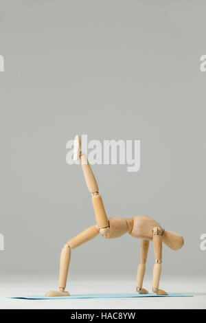 Wooden figurine exercising on exercise mat Stock Photo - Alamy