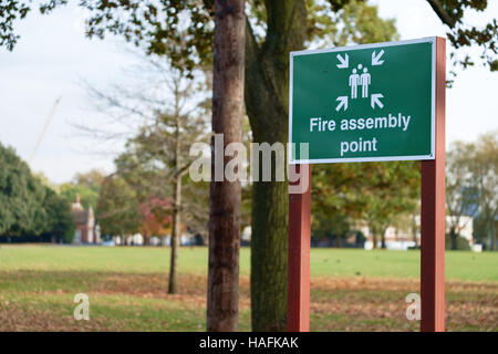 Fire assembly point sign in a car park, where people assemble after ...