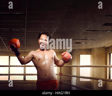 Asian boxer guy training uppercut before the game on the boxing ring ...