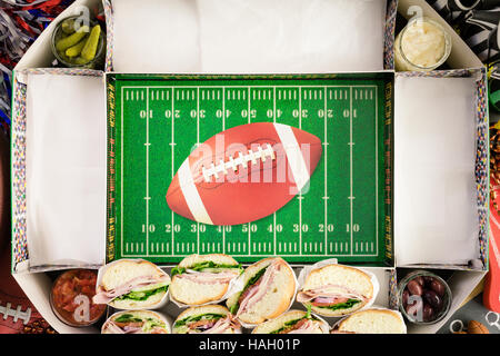 Step by step. Filling in football snack stadium with sub sandwiches ...