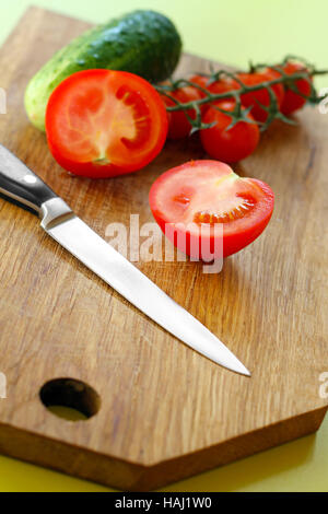 Vegetables for salad, knife and cutting board on the table. Preparation ...