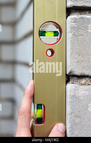 Bricklayer checking that wall is level Stock Photo - Alamy