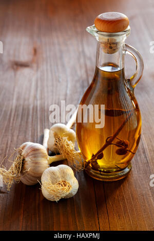 Head of garlic and olive oil bottle on a rustic table Stock Photo - Alamy