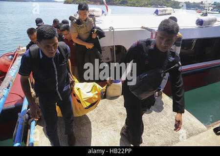 Police officers carrying a body recovered from a fire-damaged apartment ...
