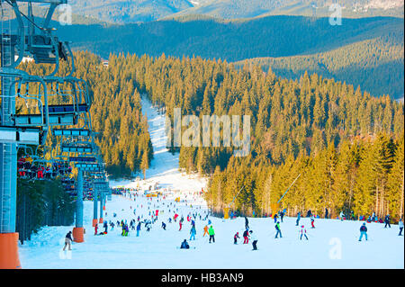 Ski resort in beautiful sunset light. View from the top: ski tracks ...