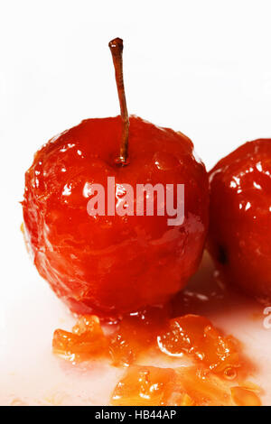 Red apples in rose syrup with small pieces of zucchini over isolated ...