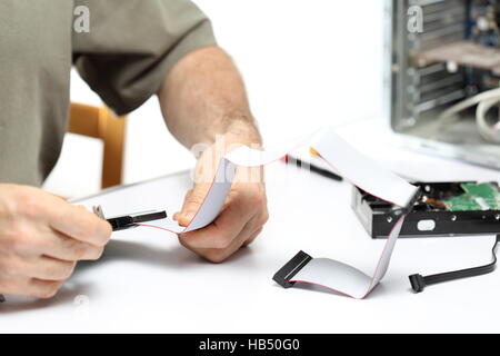 Young man repairs a computer system unit, changes parts, video card and ...