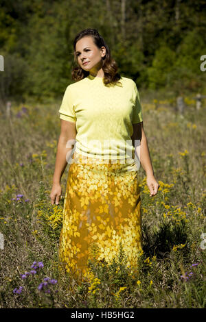 Young pretty woman wearing yellow hoodie and gray cycling shorts on ...