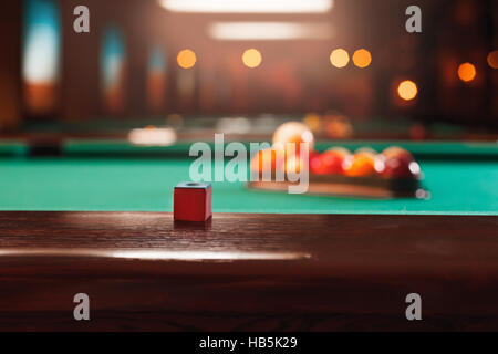 Chalk on the wooden edge of the billiard table. Balls in a pool ...