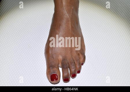 Beautiful african feet pedicured with red nail polish Stock Photo - Alamy