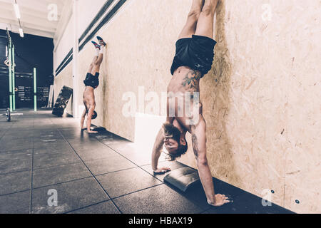 Three young men doing handstands on beach Stock Photo: 11008945 - Alamy
