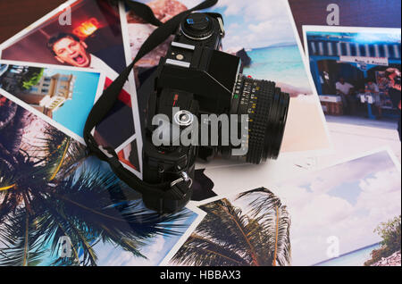 vintage photo camera on pile of old instant photos on wooden table ...