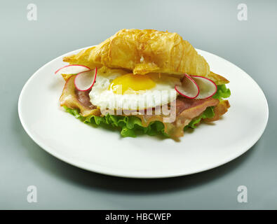 croissant sandwich breakfast with scrambled egg, crispy bacon and ...
