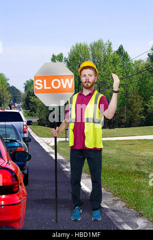 Man flagman holding a stop sign to halt traffic Stock Photo - Alamy