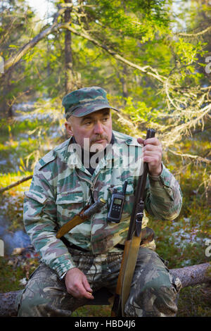 Hunter sitting on a log Stock Photo - Alamy