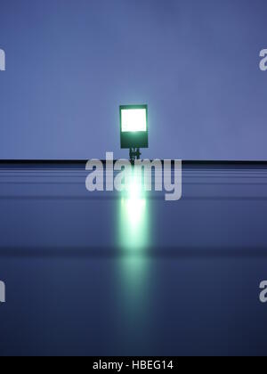 Green spotlight with a shiny projector of light rays on a black ...