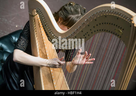 girl playing the harp on stage during a concert Stock Photo - Alamy