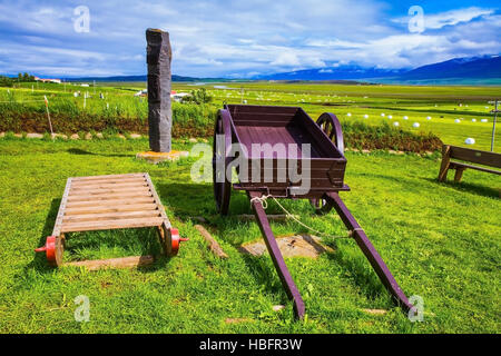 Old wooden sledge and two-wheeled cart on the lawn. The reconstituted ...