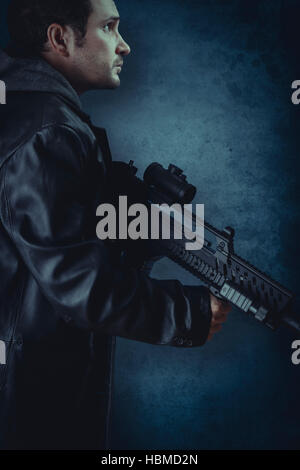 Man with long leather jacket and assault rifle over storm background ...