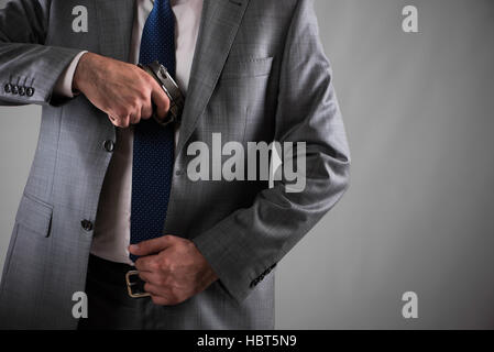 Man pulling out gun from his pocket Stock Photo - Alamy