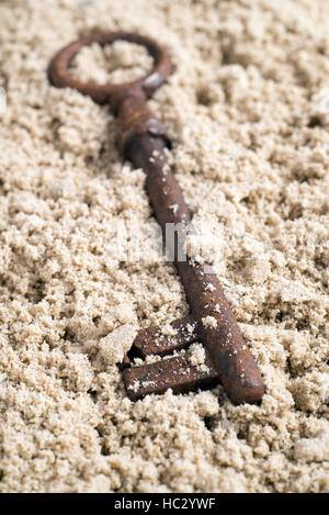 An old lost key in the sand is a newfound opportunity. The concept of ...