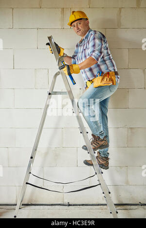 Older man leaning on ladder Stock Photo - Alamy