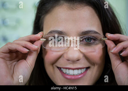 Female customer wearing spectacles in optical store Stock Photo - Alamy