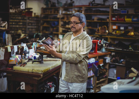 Shoemaker examining a shoe Stock Photo - Alamy